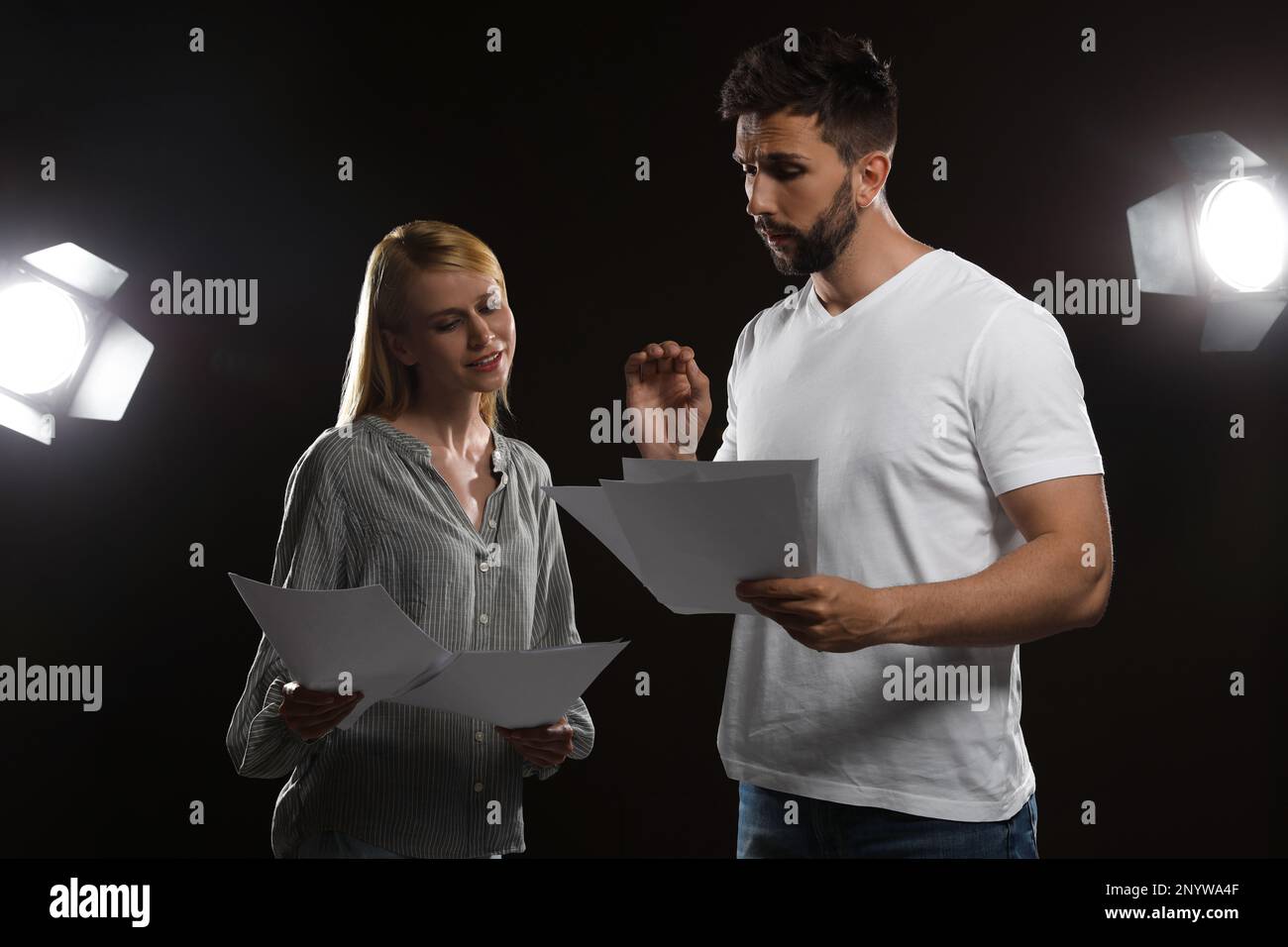 Professional actors reading their scripts during rehearsal in theatre ...