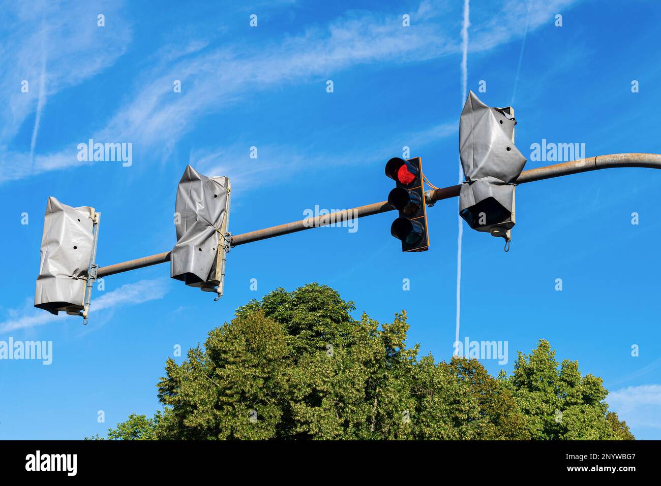 Street traffic lights on a horizontal bar under the blue sky. Three of ...