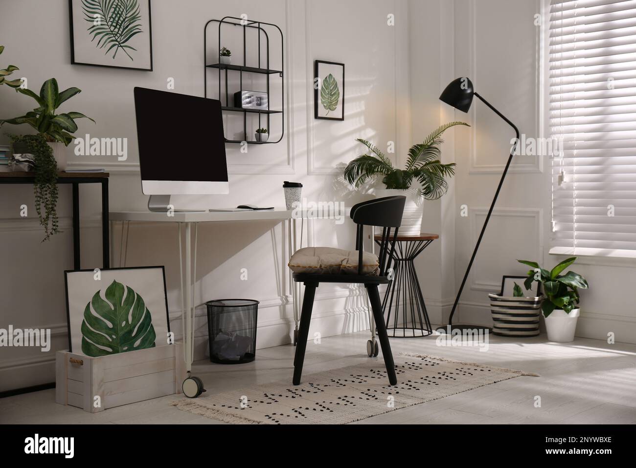 Comfortable workplace with modern computer and houseplants in room ...