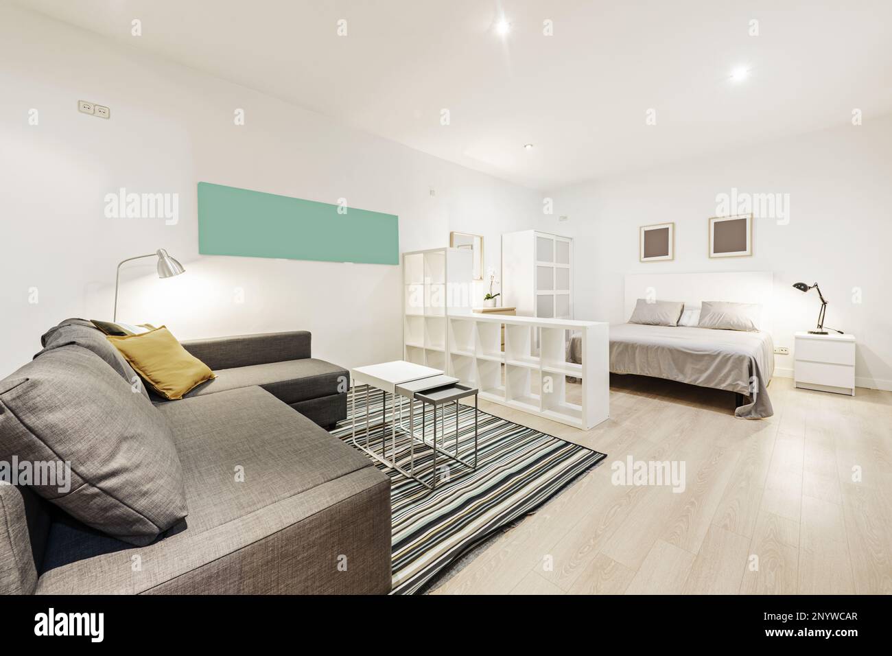 Loft-style apartment furnished with white wooden shelves, chest of ...