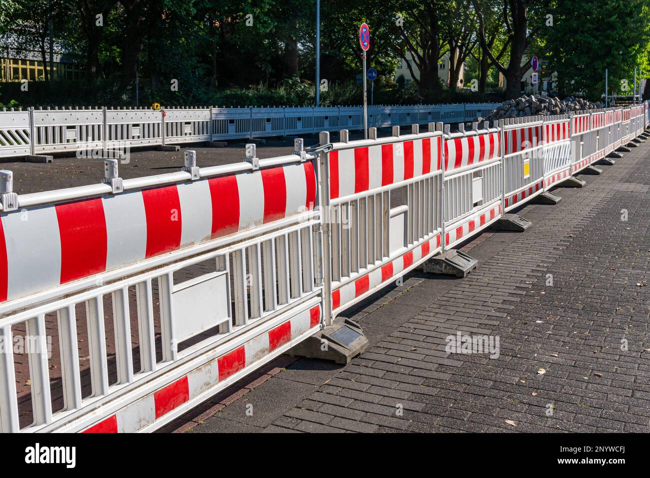 A large group of plastic barriers of white-red color stands on the ...