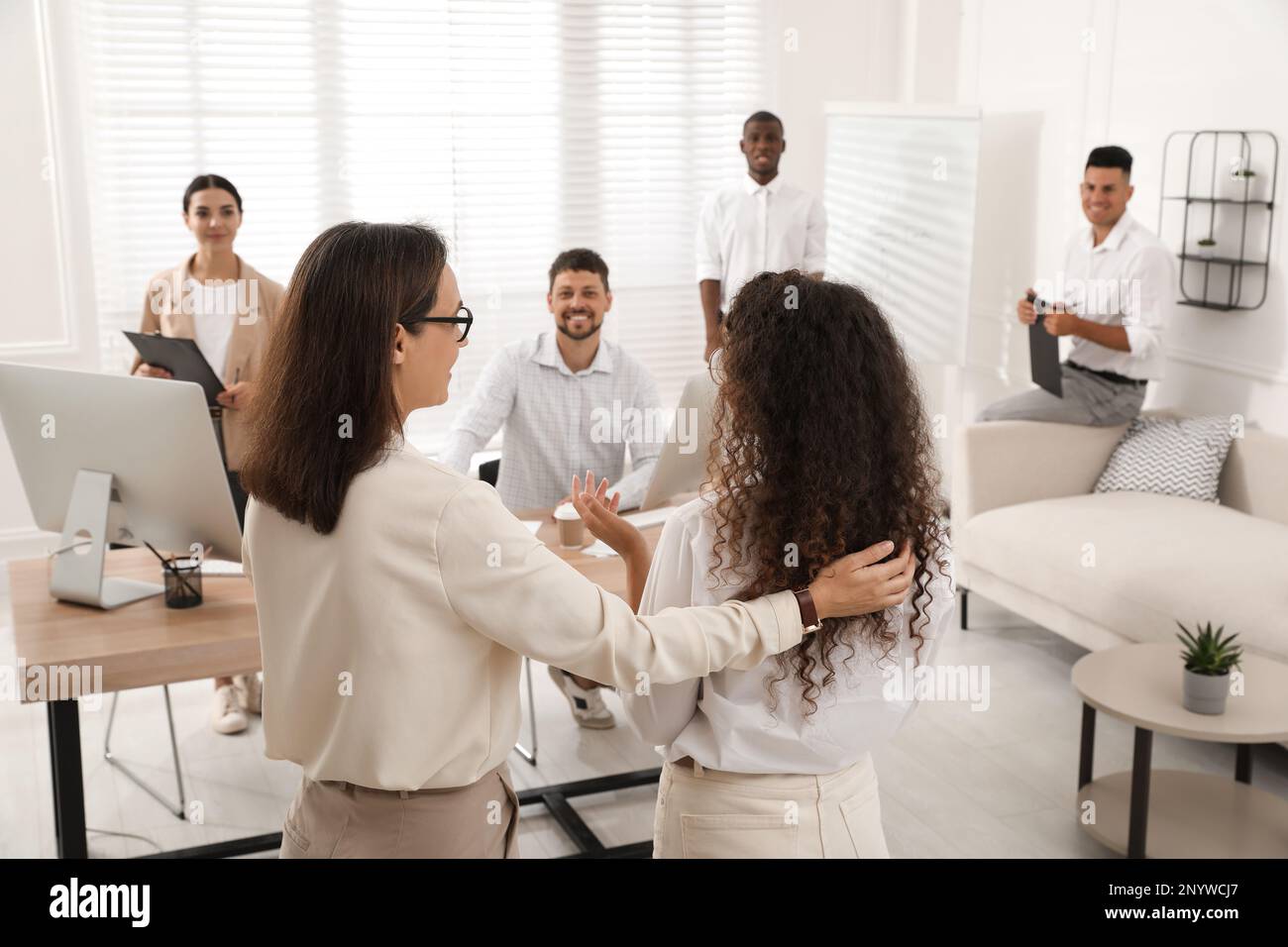 Boss introducing new employee to coworkers in office Stock Photo - Alamy