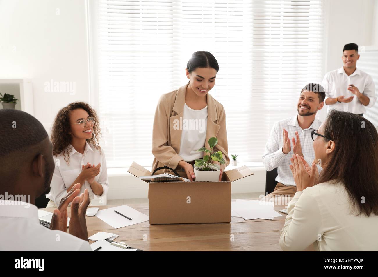 Group of coworkers welcoming new employee in team indoors Stock Photo ...