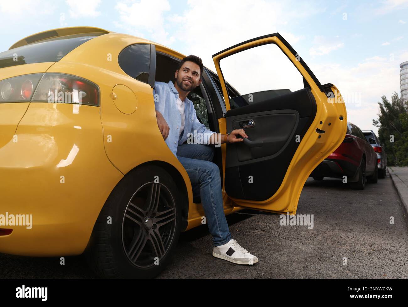 Smiling man opening car city street hi-res stock photography and images ...