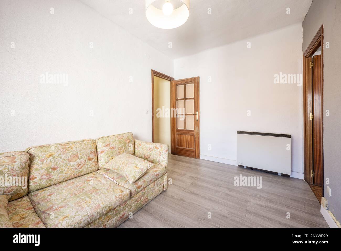 Living room of a semi-empty house with three-seater sofa with patterned ...