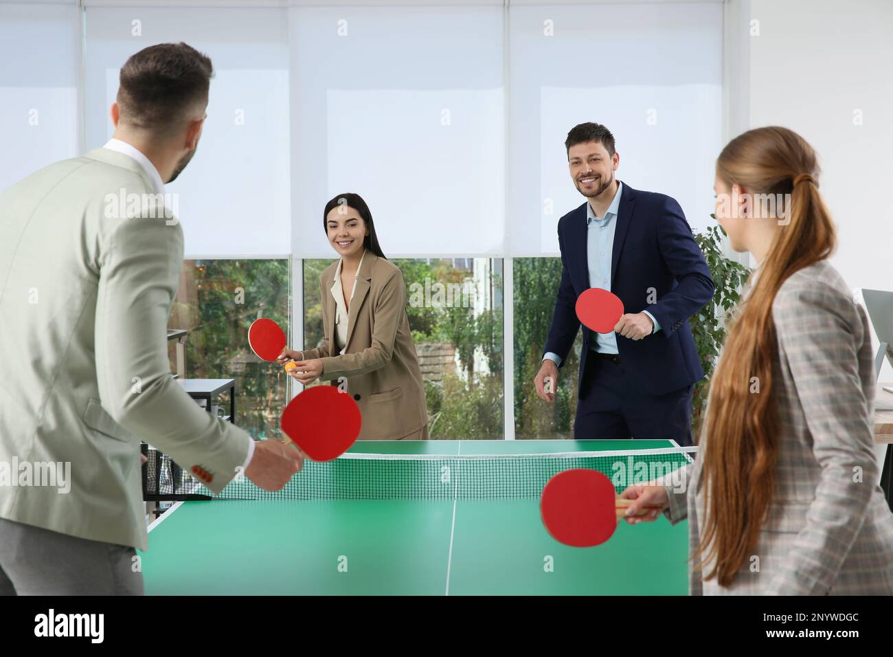 Business people playing ping pong in office Stock Photo - Alamy