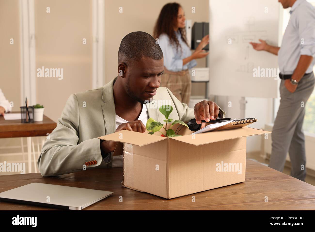 New coworker unpacking box with personal items at workplace in office ...