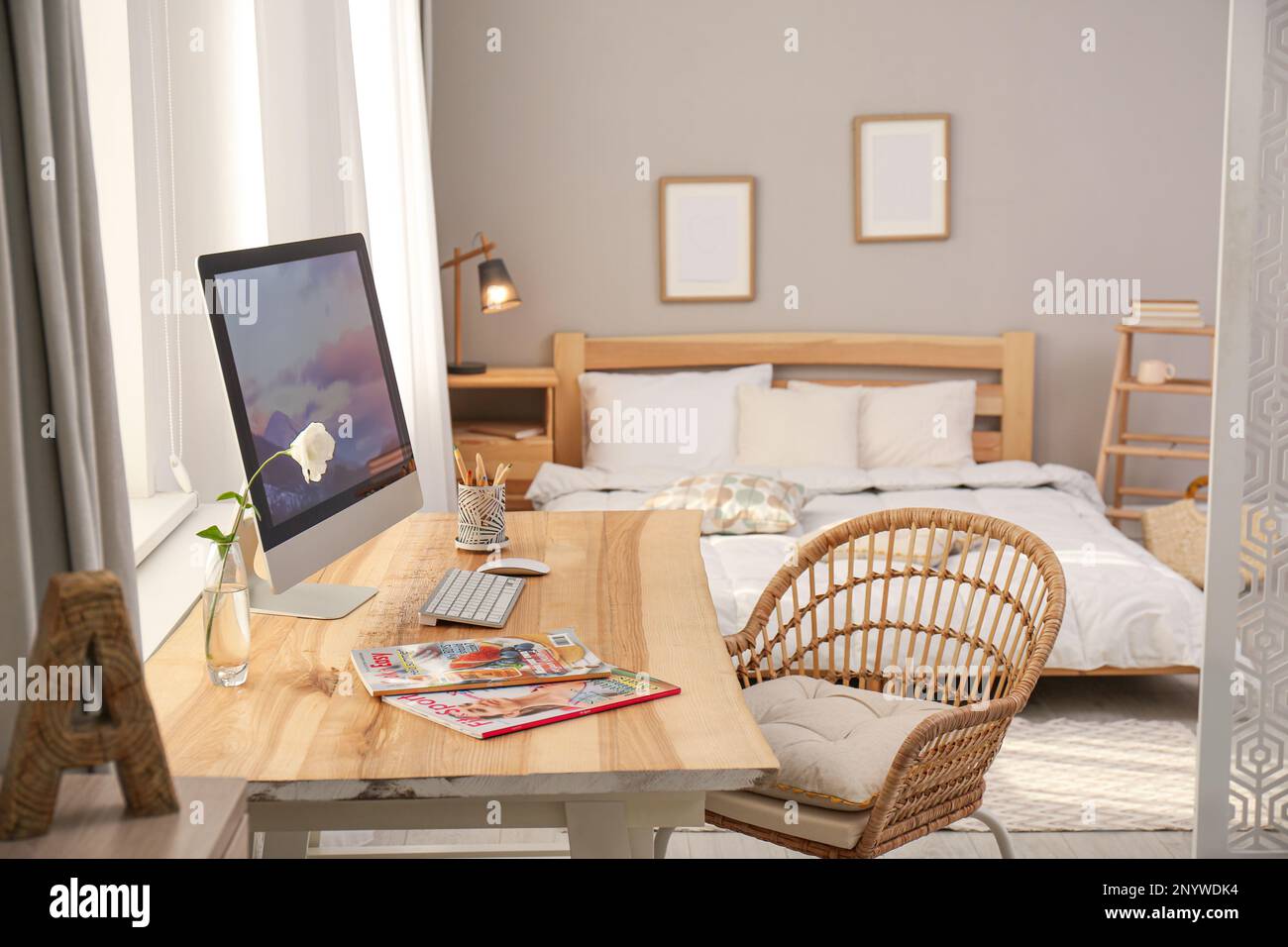 Comfortable workplace with modern computer near window in bedroom ...
