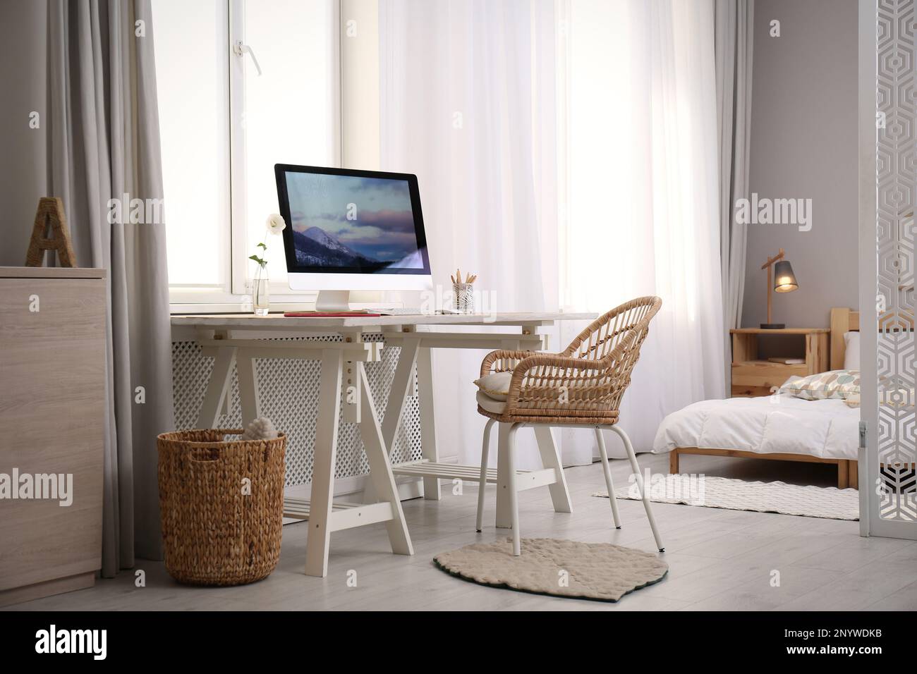 Comfortable workplace with modern computer near window in bedroom ...