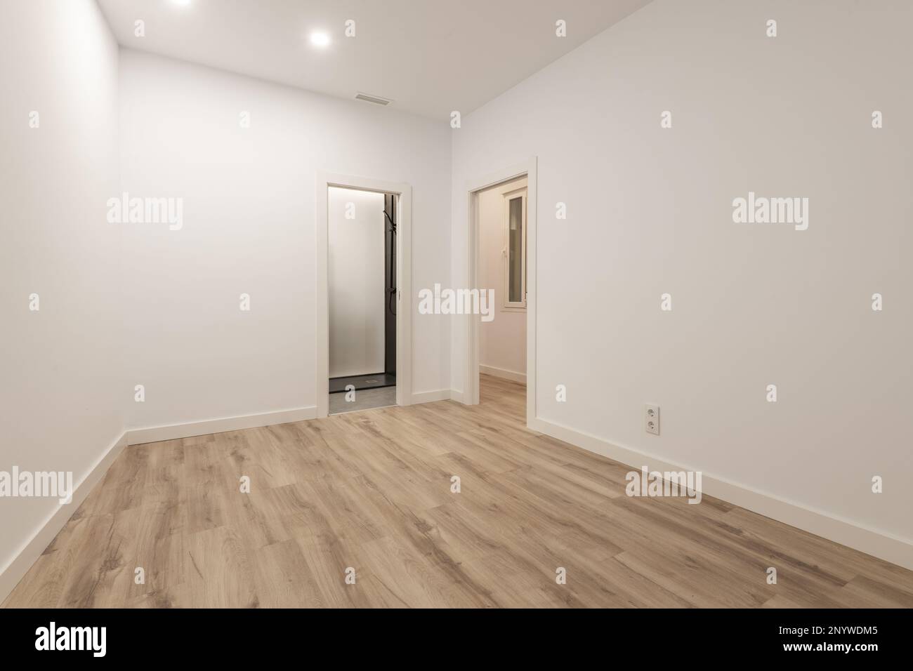 Empty loft-style apartment with white trim on doors and baseboards ...