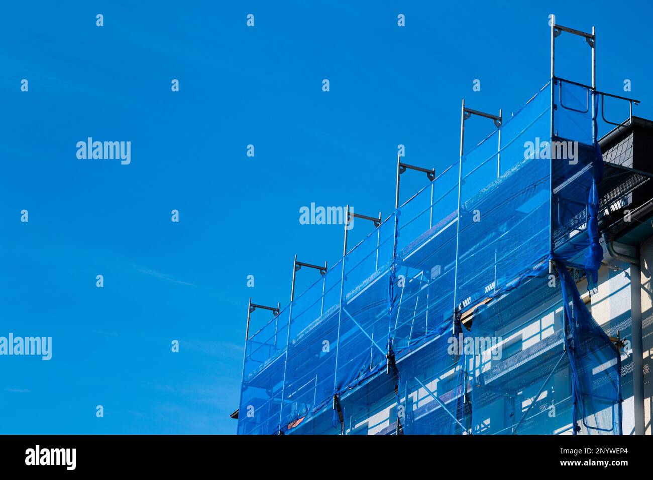 Part of the building surrounded by scaffolding scaffolding and netting ...