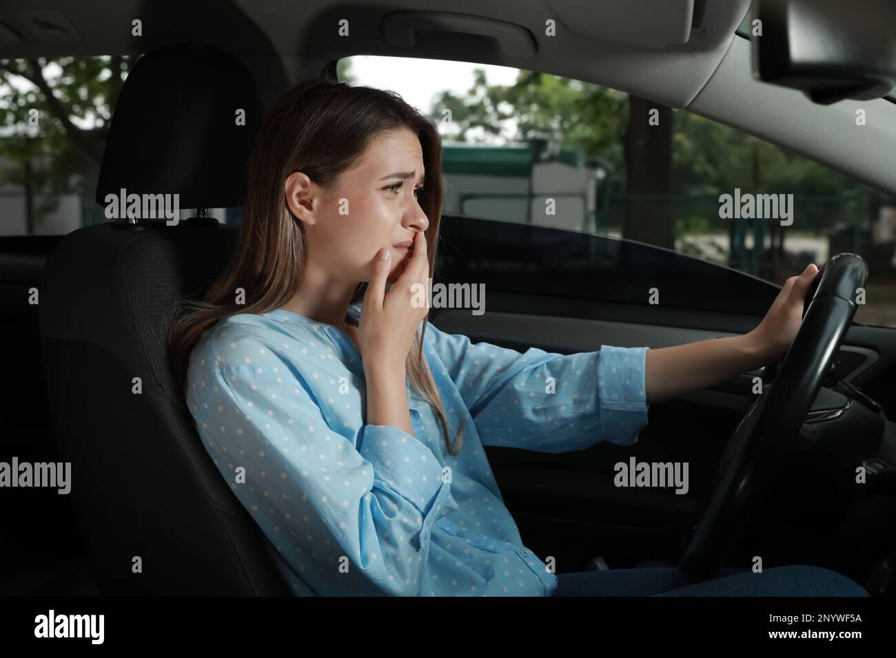 Stressed young woman in driver's seat of modern car Stock Photo - Alamy