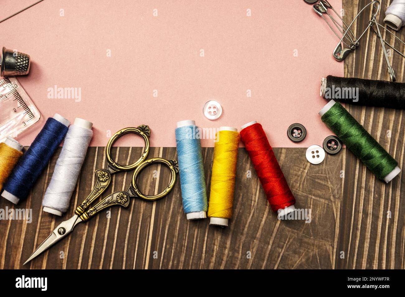 Sewing still life with sewing threads, buttons, a golden scissors, a ...