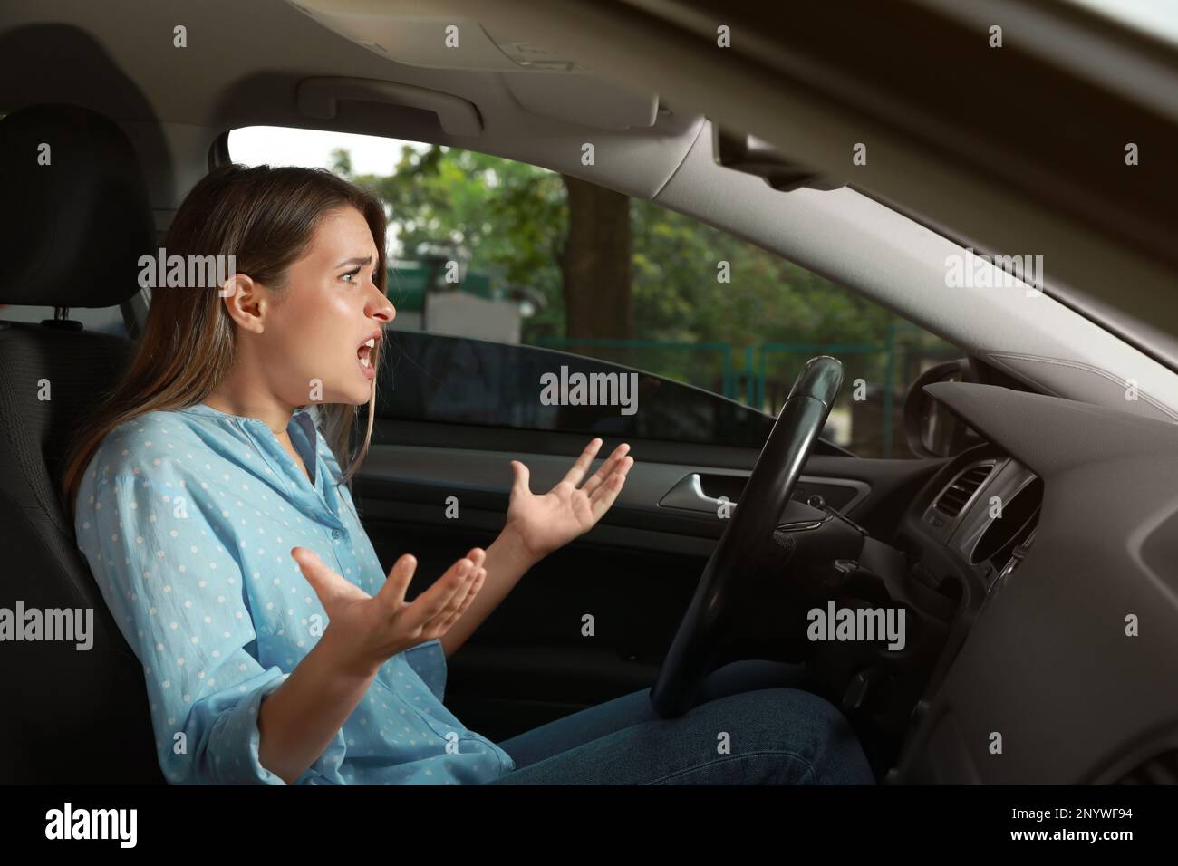 Stressed young woman in driver's seat of modern car Stock Photo - Alamy