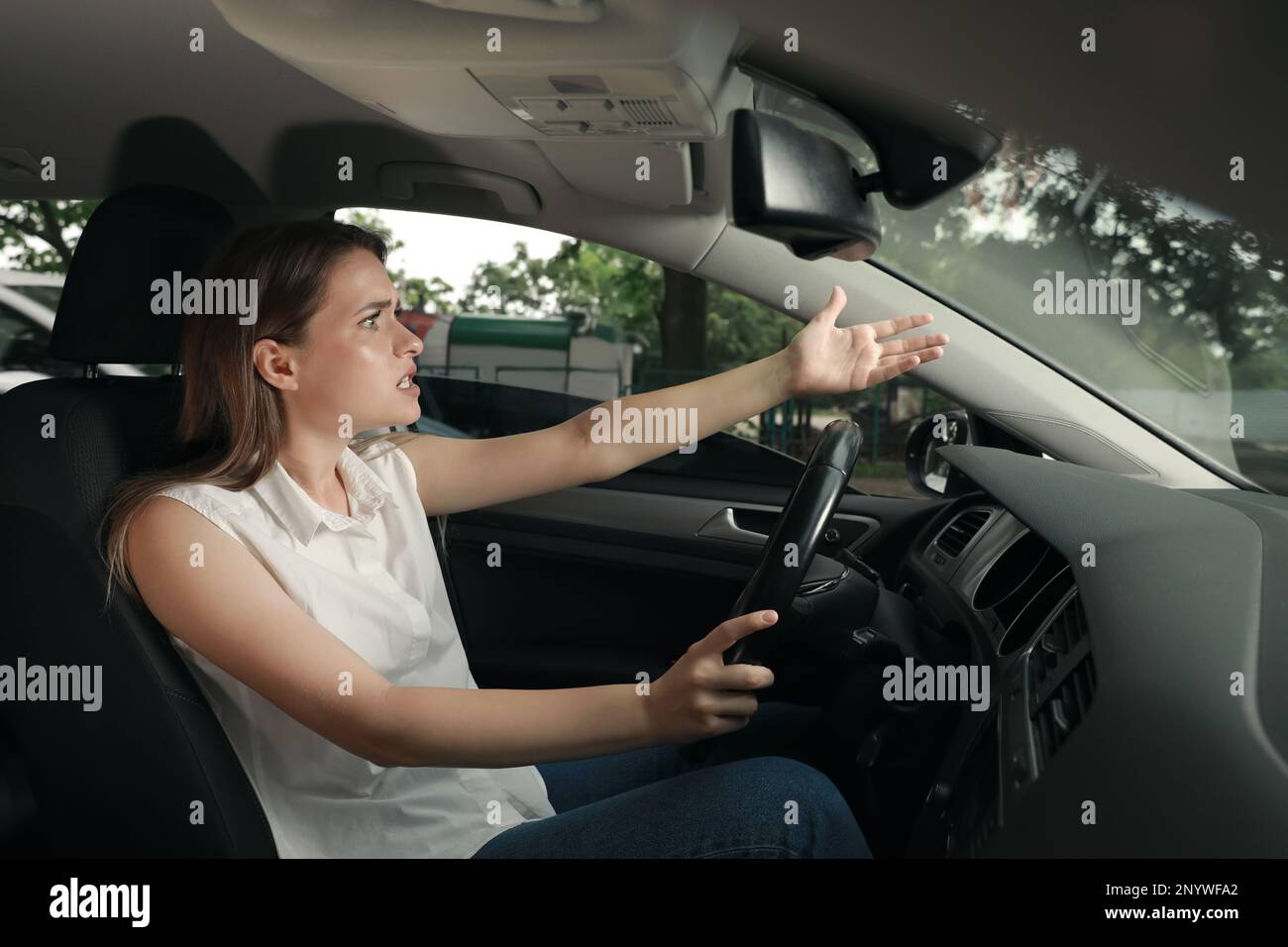 Stressed young woman in driver's seat of modern car Stock Photo - Alamy