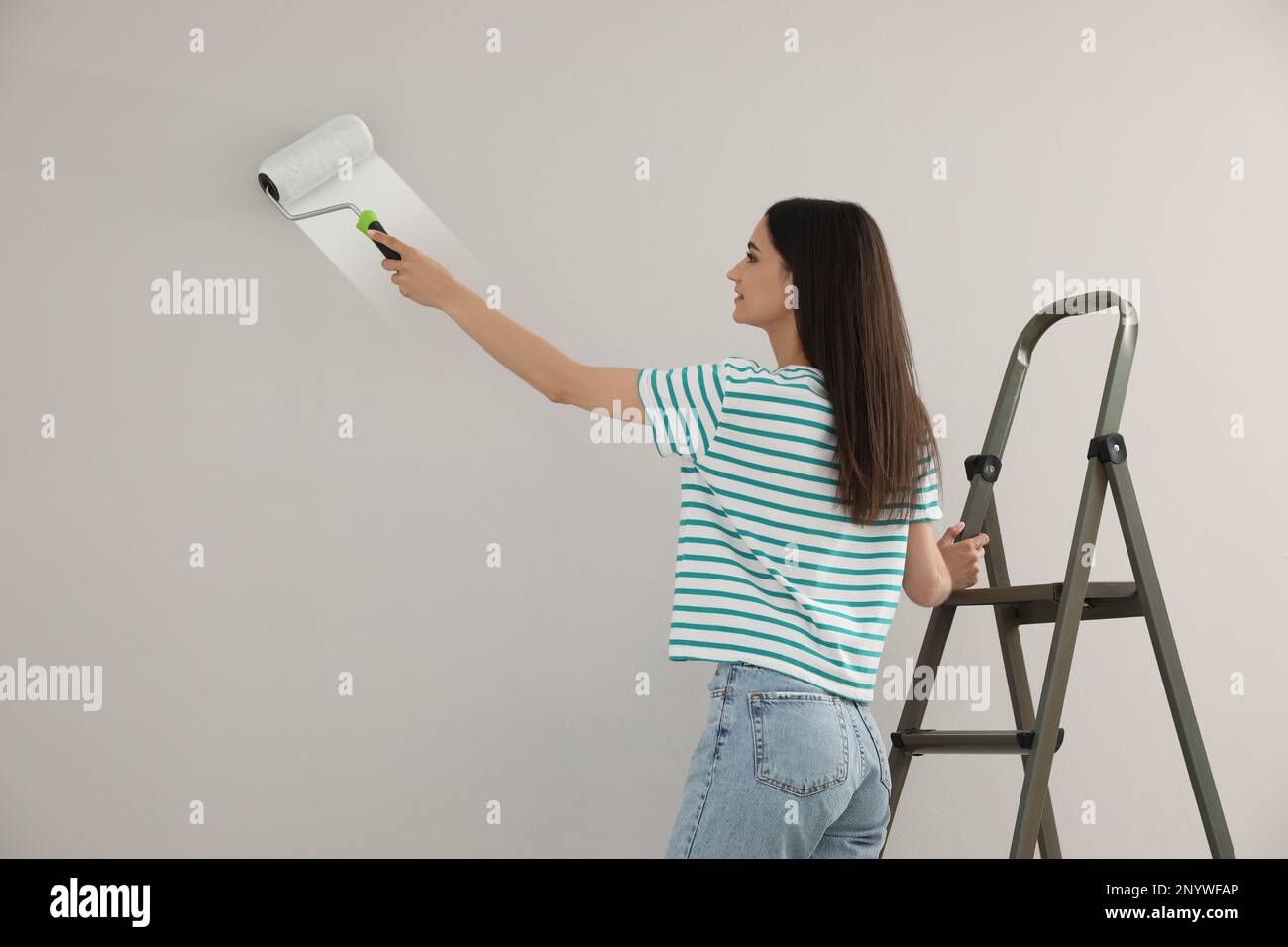 Woman on ladder painting wall hi-res stock photography and images - Alamy