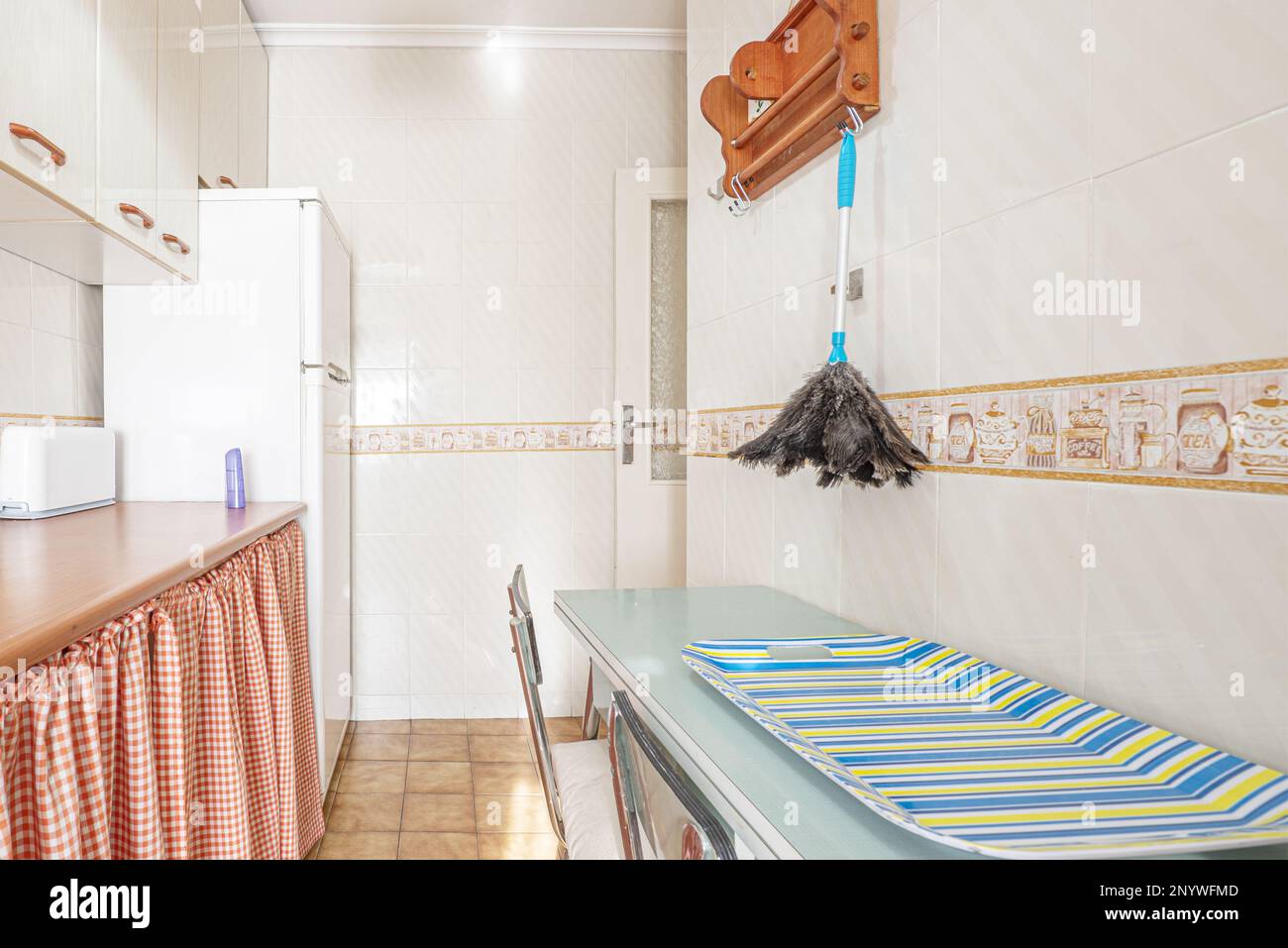 Corner of a small kitchen with a folding table made of Formica with ...