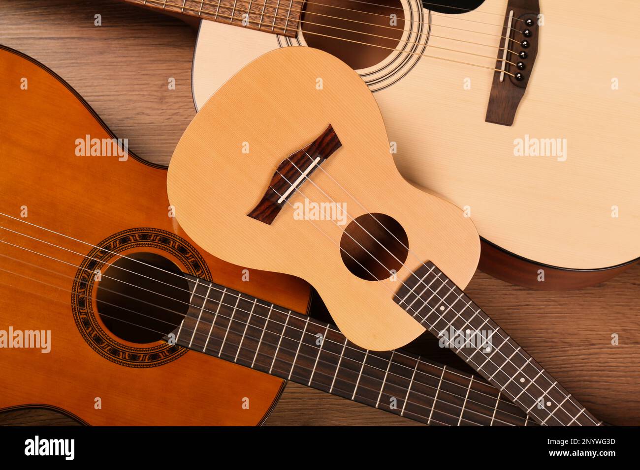 Ukulele and acoustic guitars on wooden background, flat lay. String ...