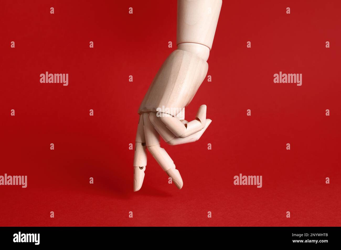 Wooden hand model on red background. Mannequin part Stock Photo - Alamy