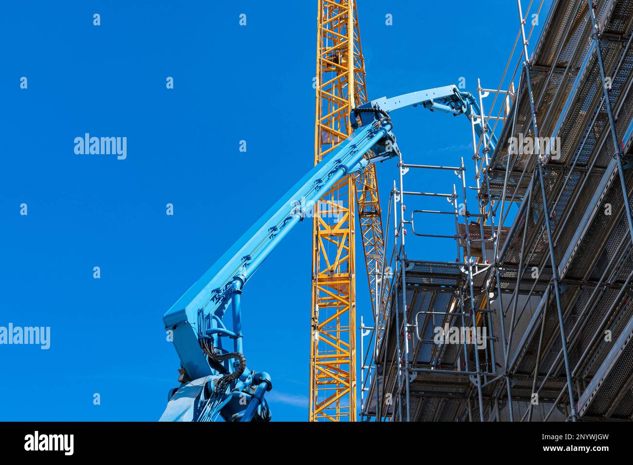 Arrows of blue and yellow construction cranes on the background of ...