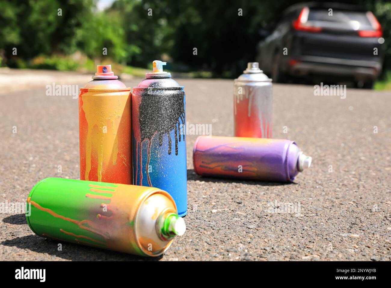 Used cans of spray paint on asphalt road. Graffiti supplies Stock Photo ...