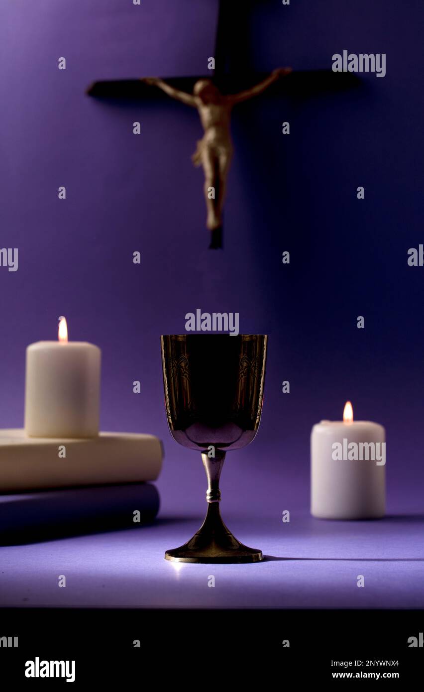silhouette of golden christian chalice with candles flame and crucifix ...