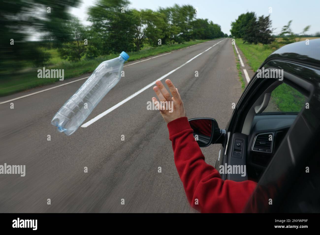 Driver throwing away plastic bottle from car window. Garbage on road ...