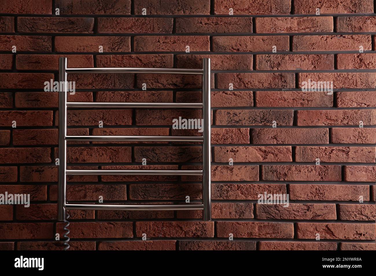 Modern heated towel rail on red brick wall. Space for text Stock Photo ...