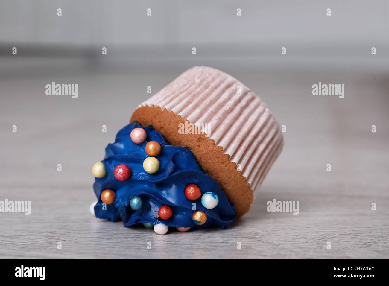 Dropped cupcake with cream on floor, closeup. Troubles happen Stock ...