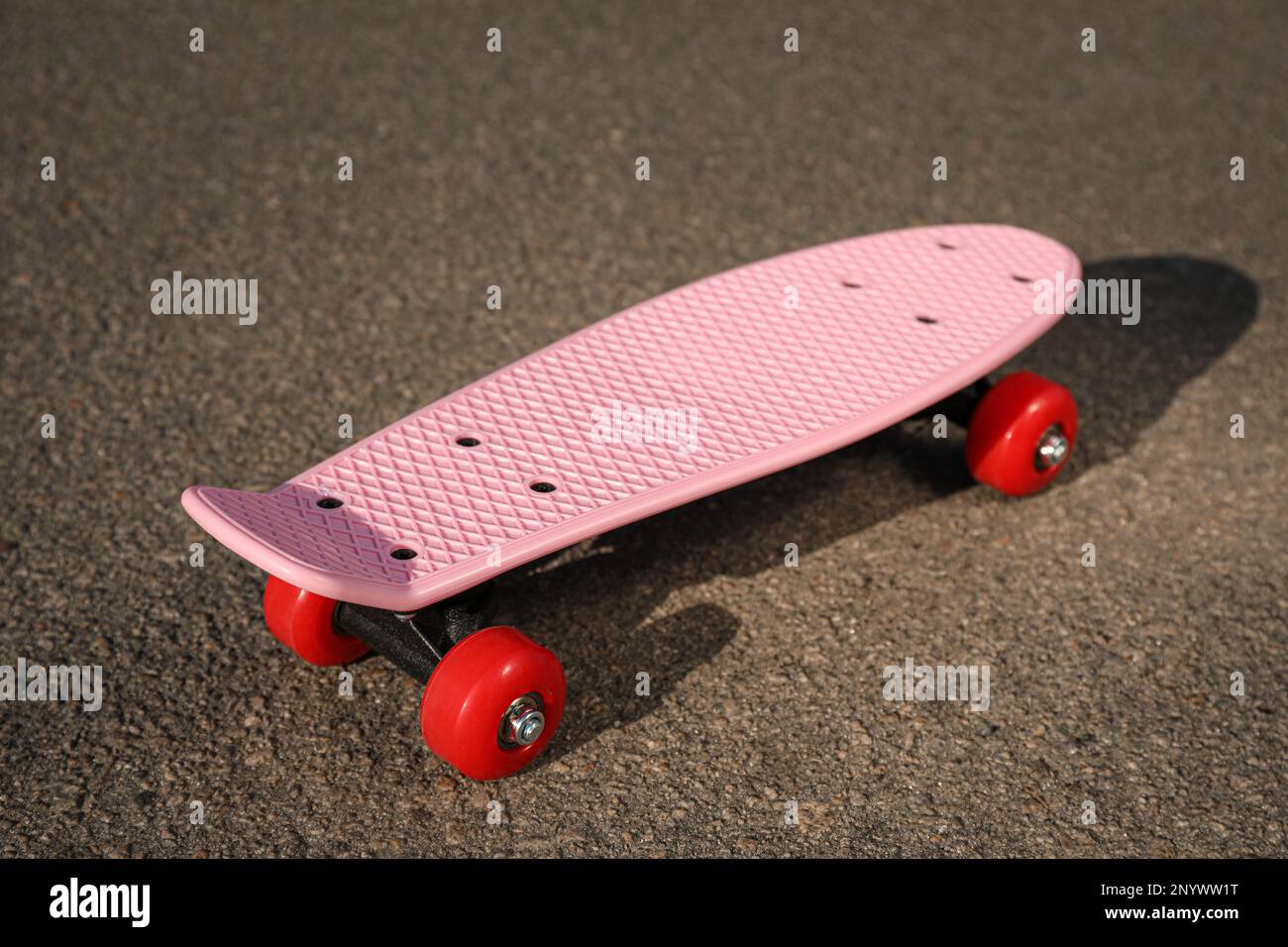 Pink skateboard with red wheels on asphalt outdoors Stock Photo - Alamy