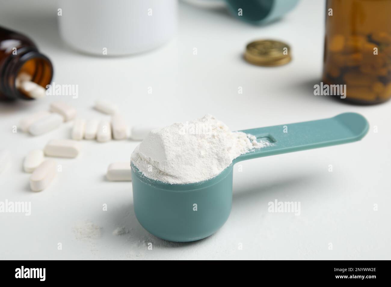 Measuring scoop of amino acids powder on white table Stock Photo - Alamy