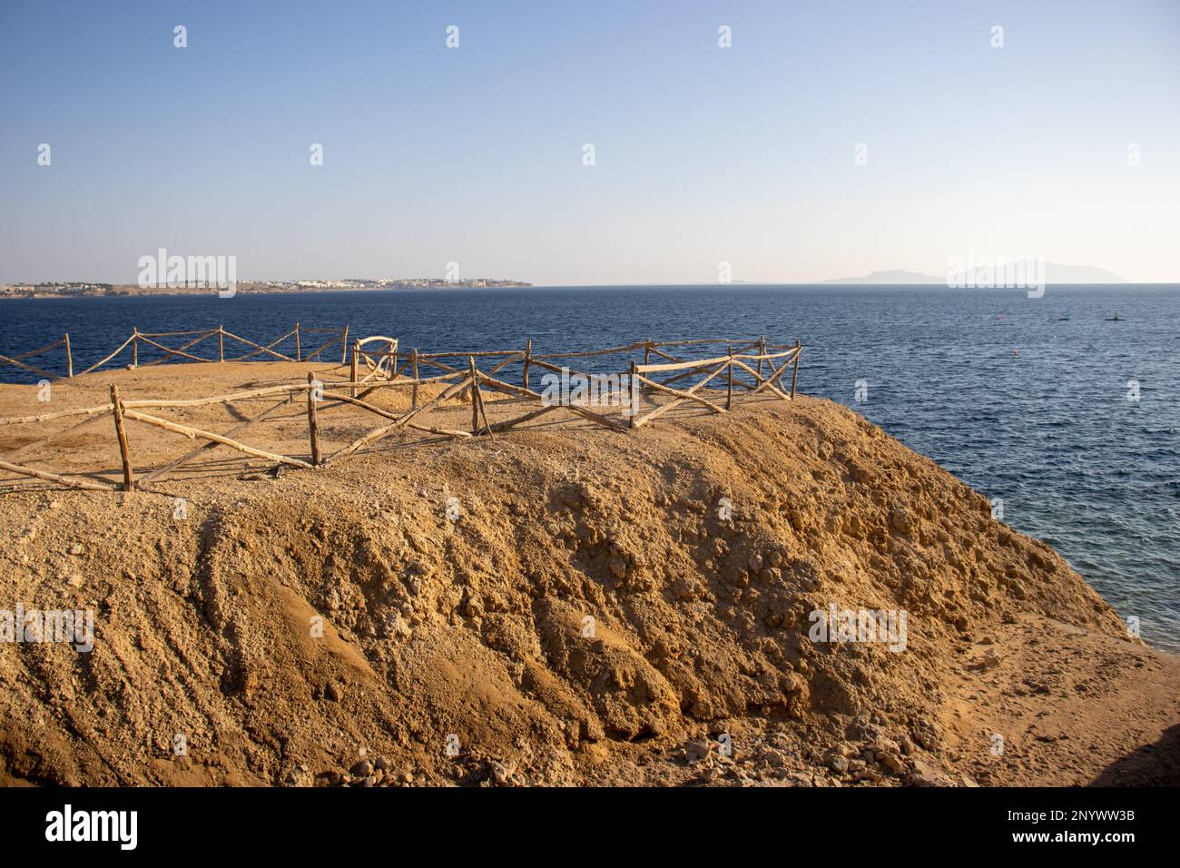 Desert coast line with dark blue water and clear blue sky Stock Photo ...