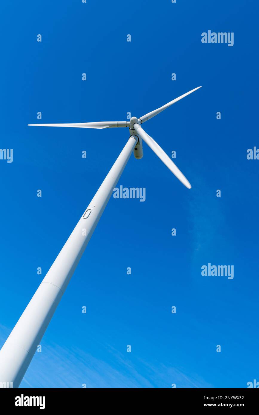 Shot of windmill spinning against the blue sky, wind energy farm ...