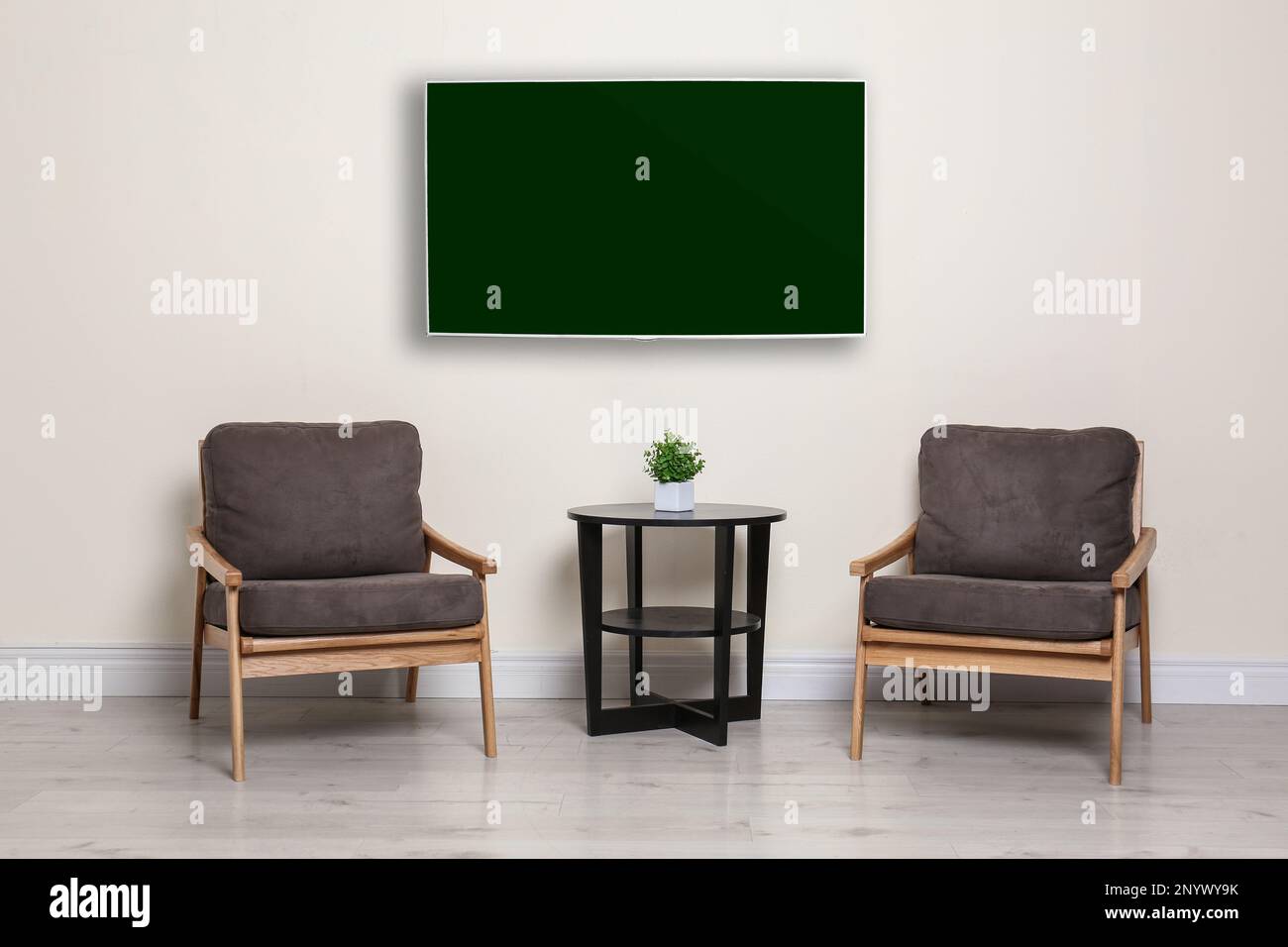 Modern wide screen TV on white wall in room with stylish furniture ...