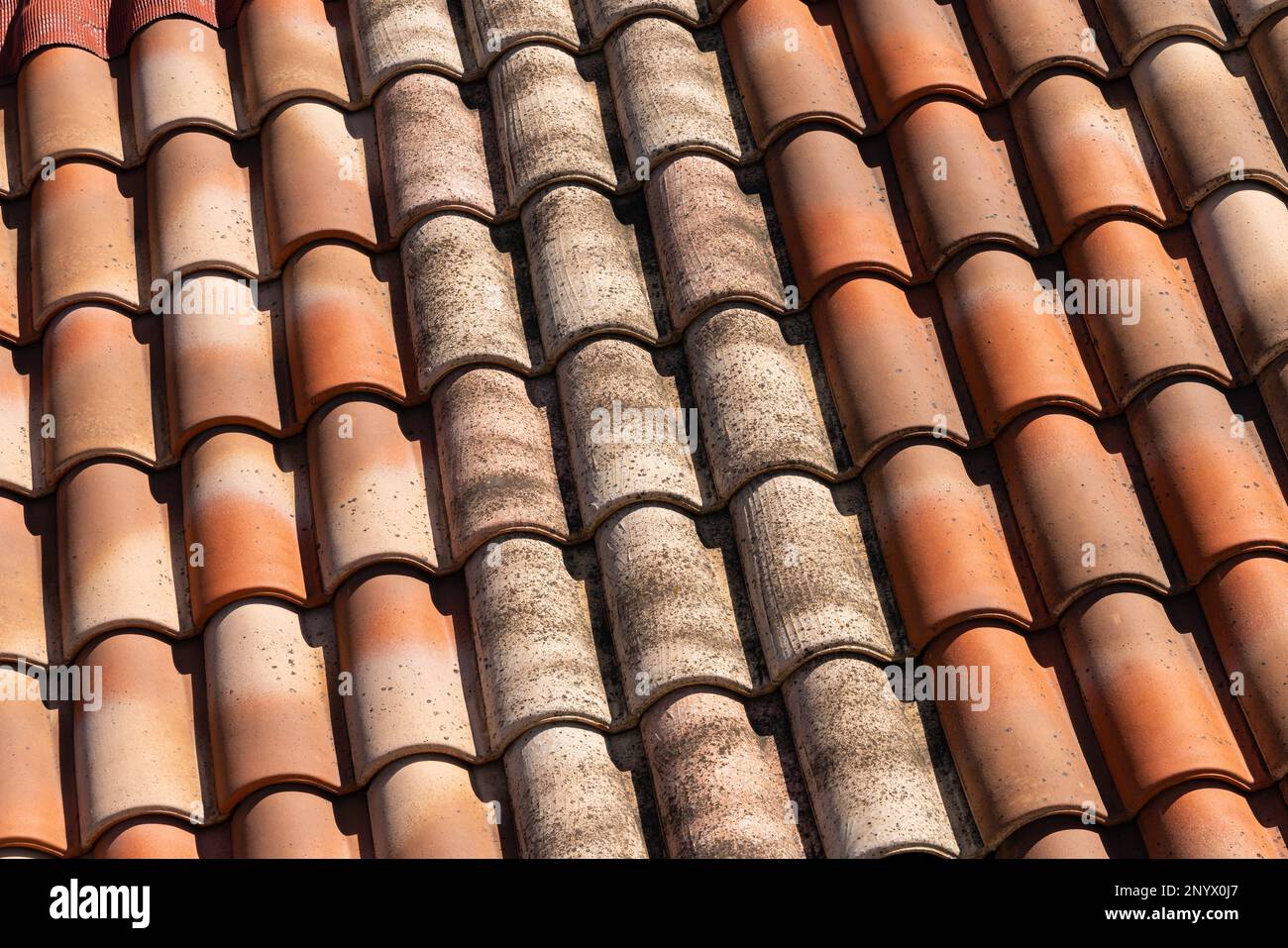 Fragment of a tiled roof close-up. The tile under the influence of ...