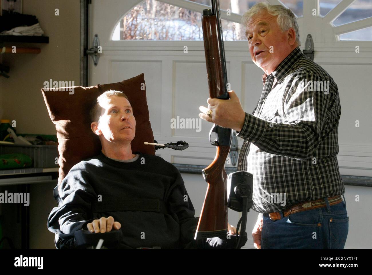 Mark's dad, Duane Schuh, shows him a new shotgun he recently acquired ...