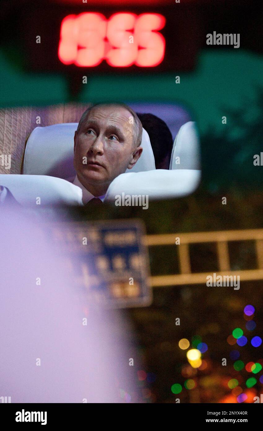 Russian President Vladimir Putin is reflected in a bus rear view mirror ...