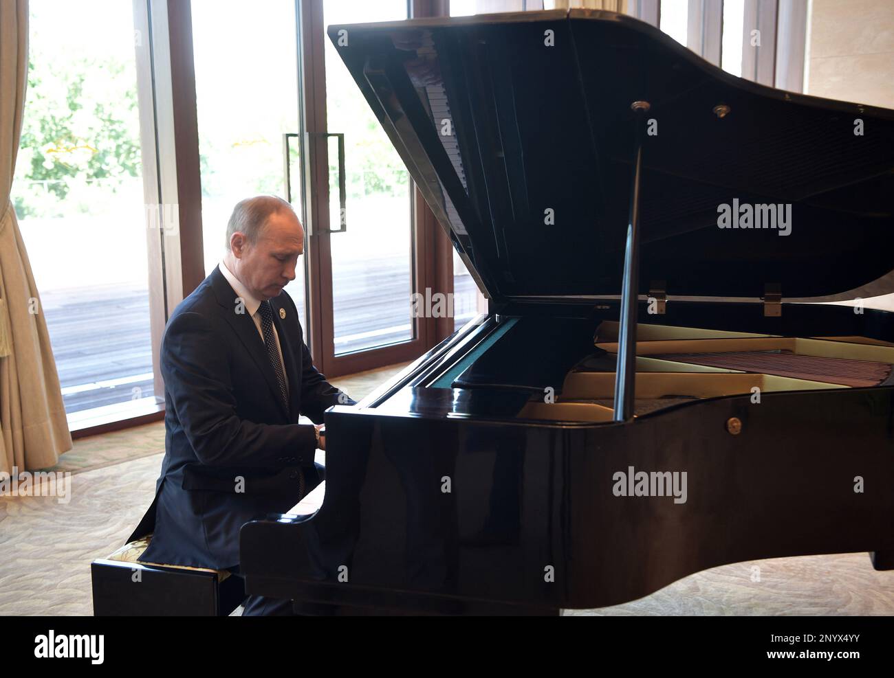 Russian President Vladimir Putin plays piano before his talks with ...