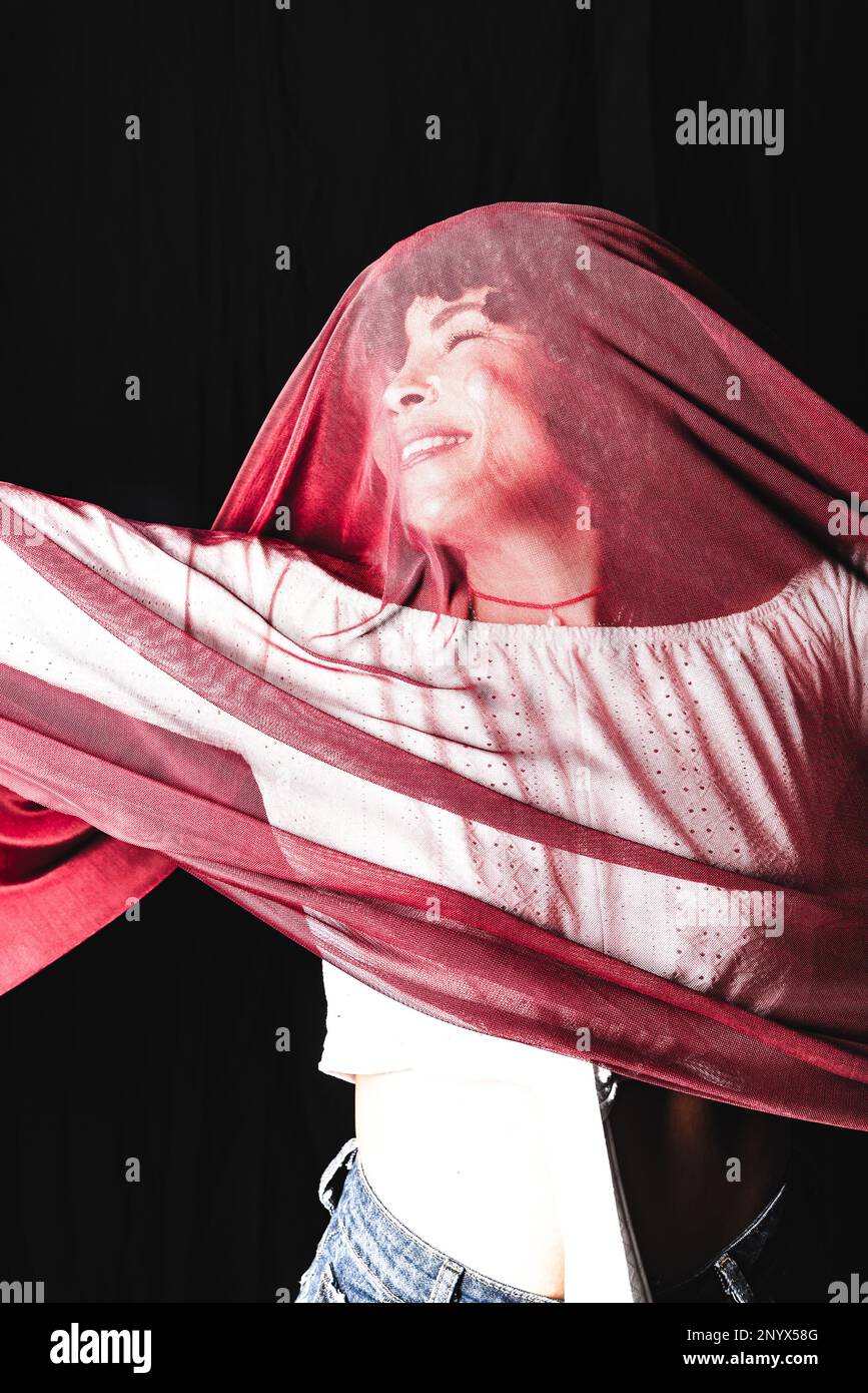 Beautiful woman with red cloth over her head making hand gestures ...