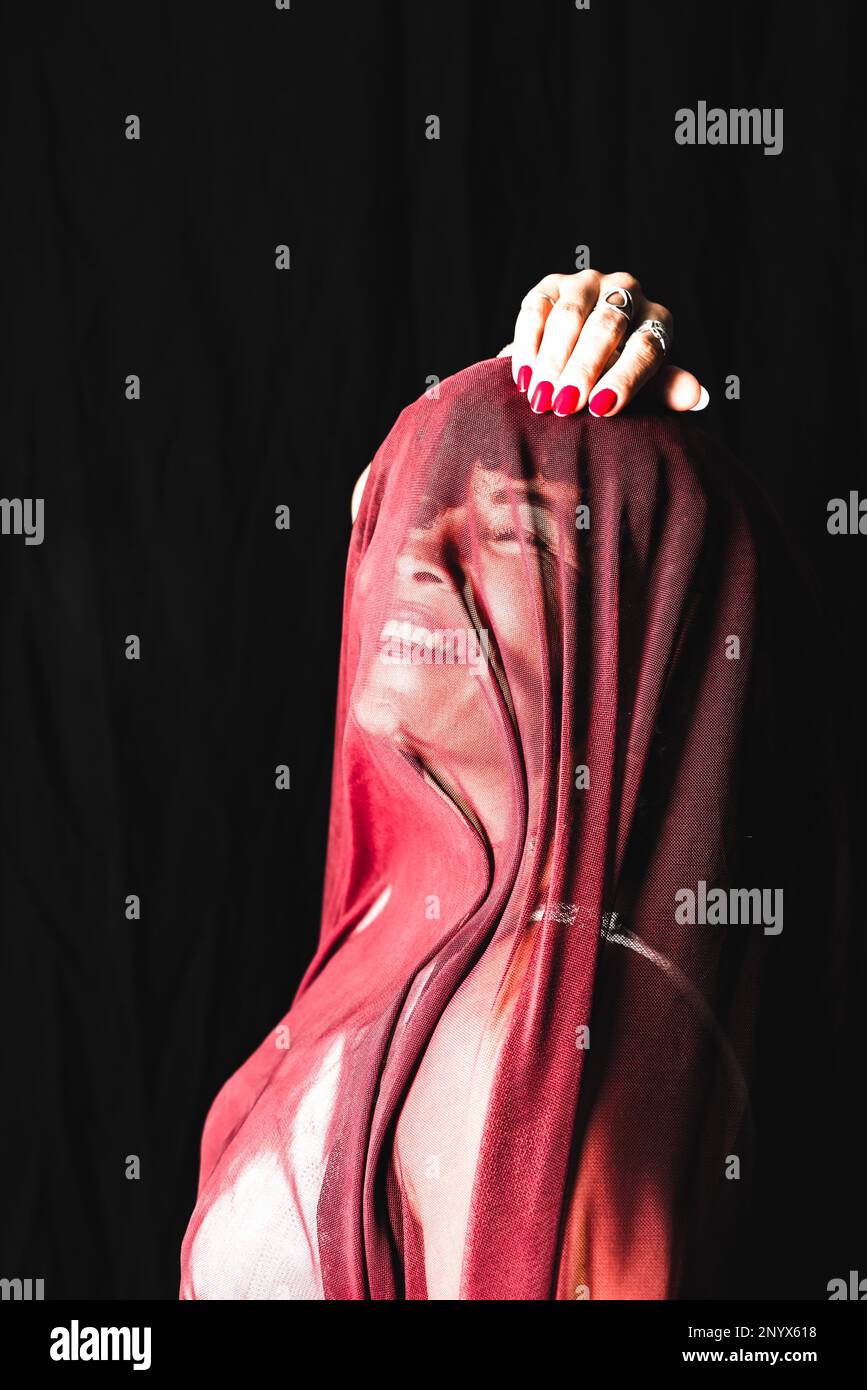 Beautiful woman with red cloth over her head making hand gestures ...