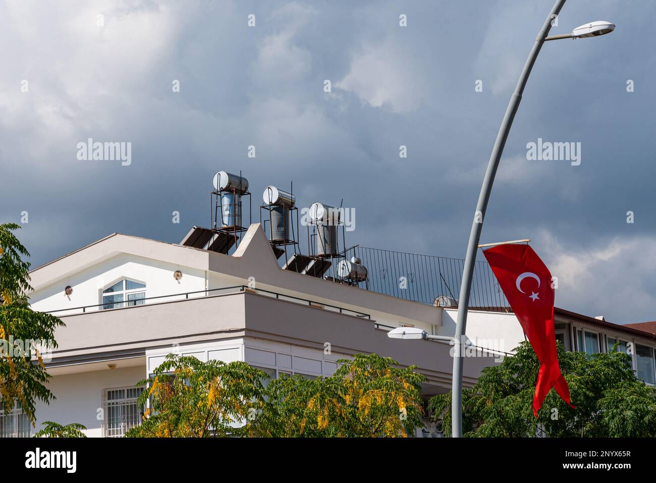 Roof of a house with tanks for heating water. The Turkish flag flies on ...