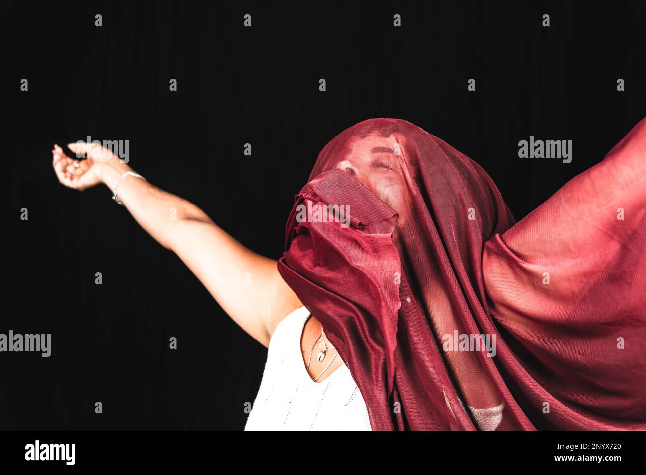 Beautiful woman with red cloth over her head making hand gestures ...