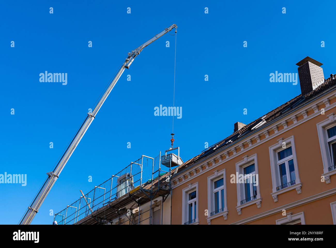 Crane boom over a residential building falling building material on the ...