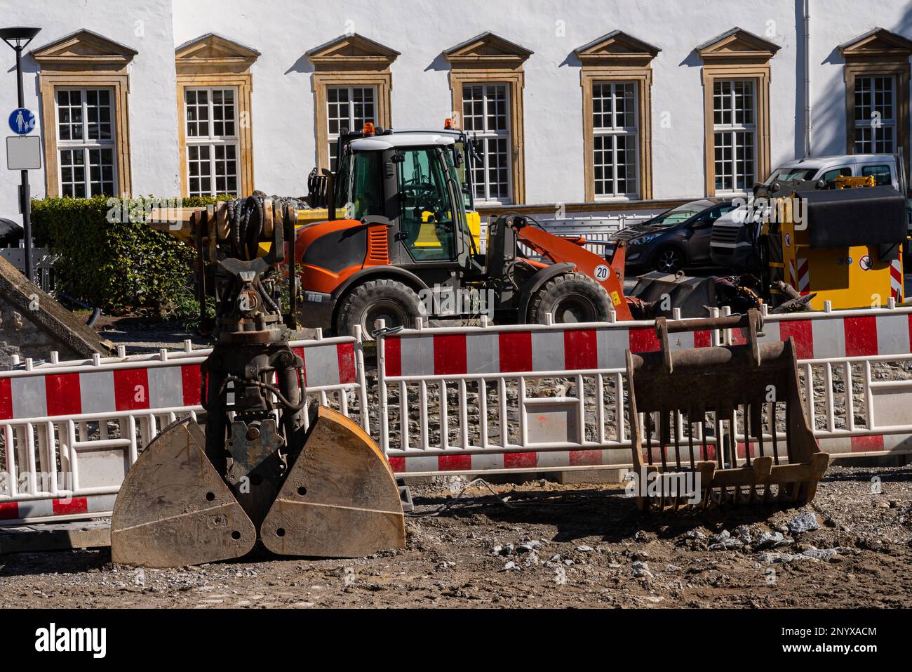 Excavator and different buckets at the construction site. White ...