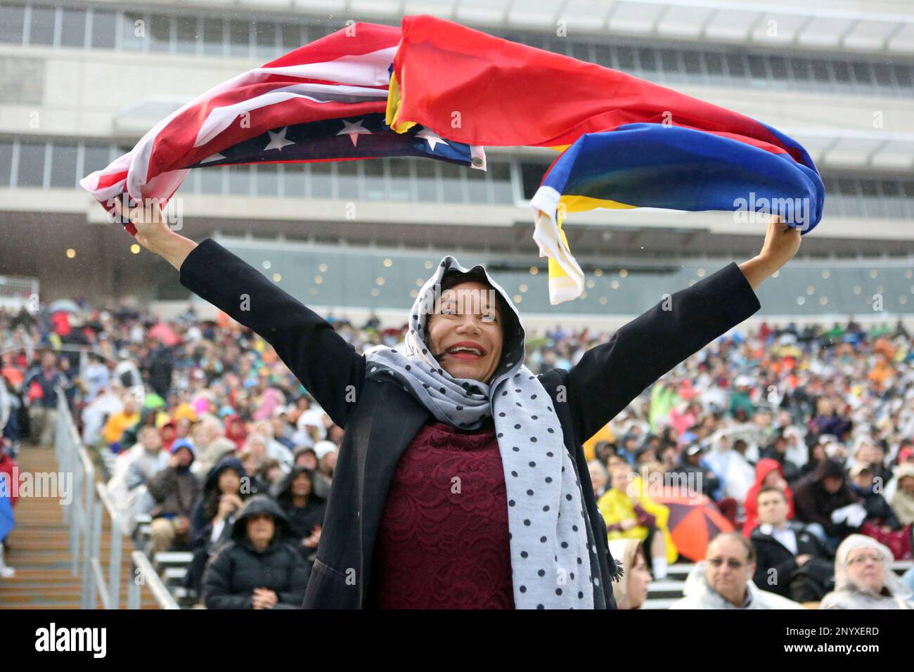 Parent Elena Lewis waves an American and Columbian flag in an effort to ...