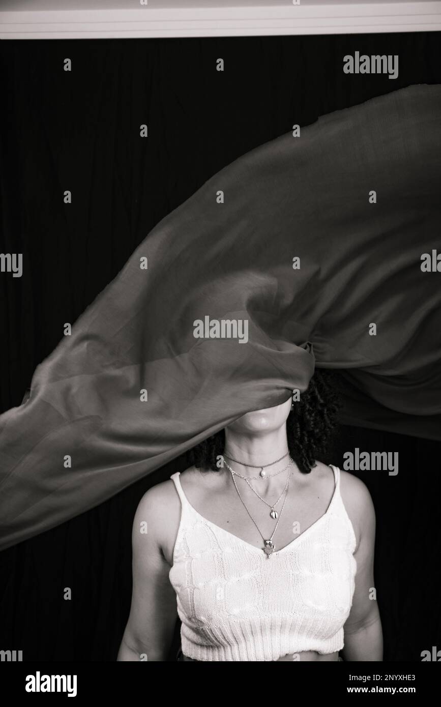 Black and white portrait of woman throwing cloth in the air. Isolated ...