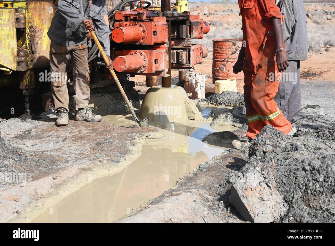 Local contractors work around and monitor well drilling operations ...