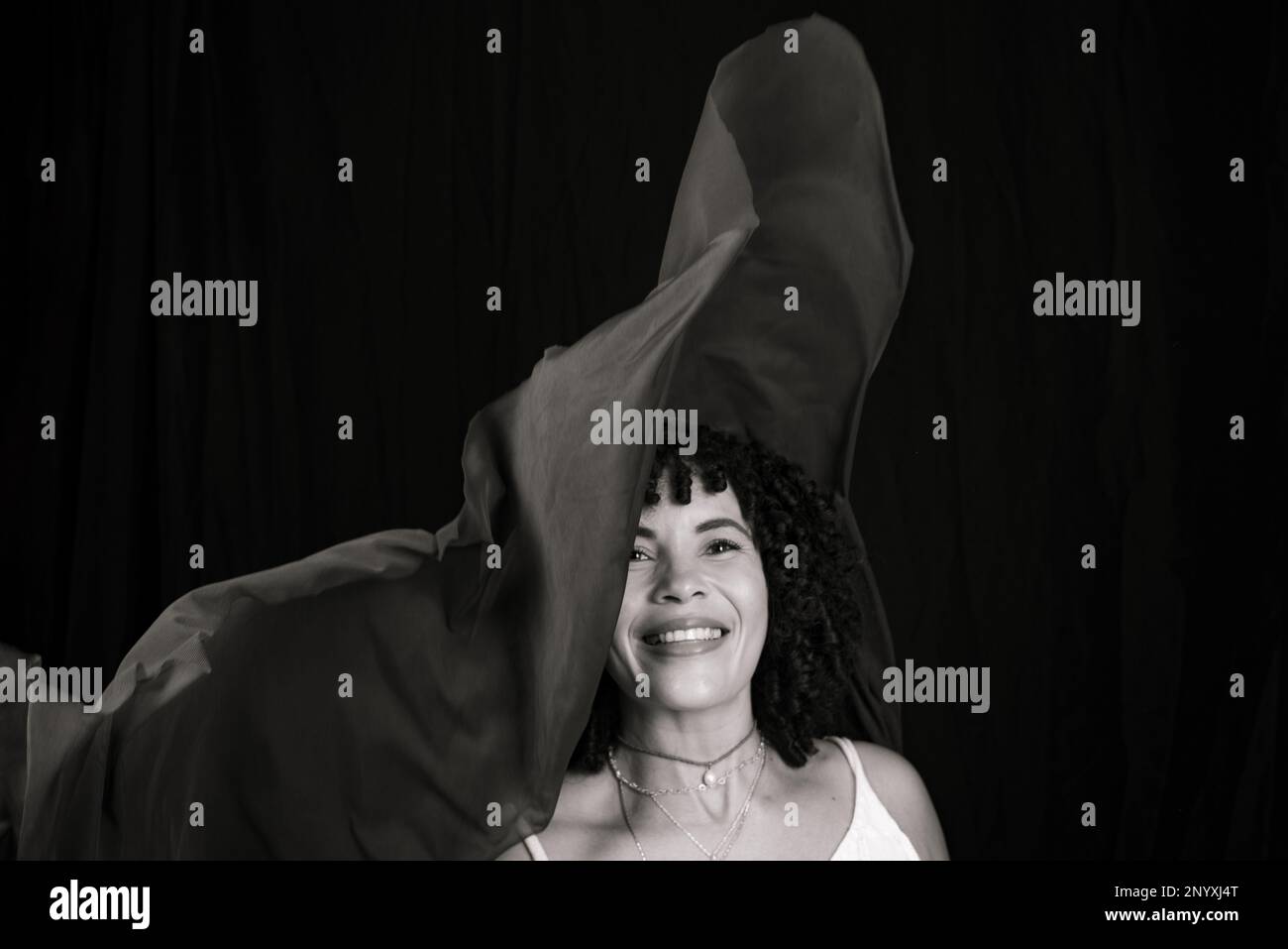 Black and white portrait of woman throwing cloth in the air. Isolated ...
