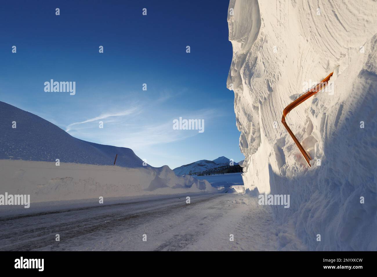 A damaged road marker extends from snowbanks in Mammoth Lakes, CA after ...