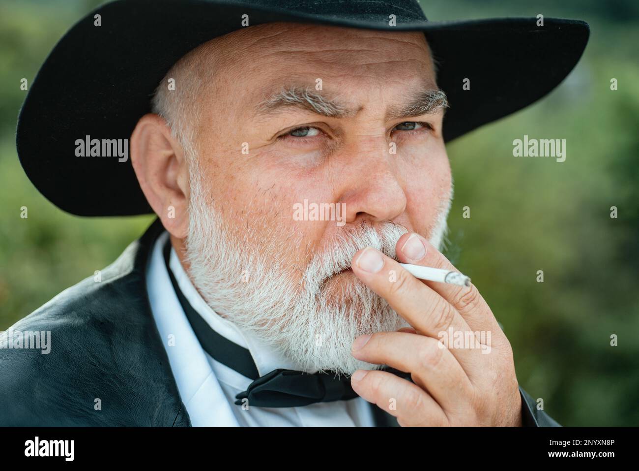 Old man smoking cigarette. Attractive elderly mature man. Face of ...